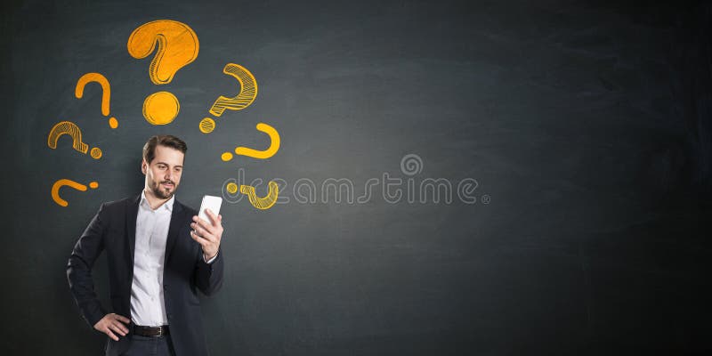 Businessman Looking at Smartphone with Question Marks on Chalkboard ...