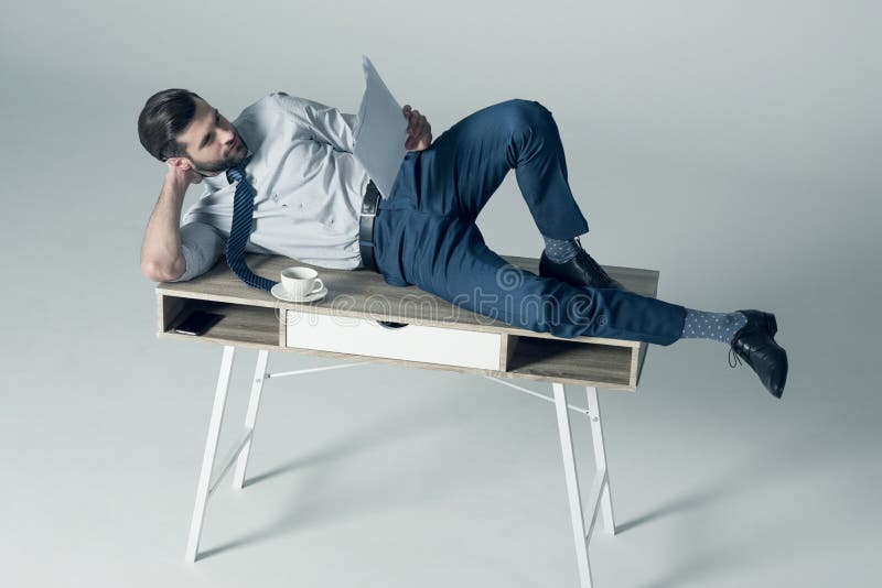 Businessman lying on table stock image. Image of workplace - 90422103