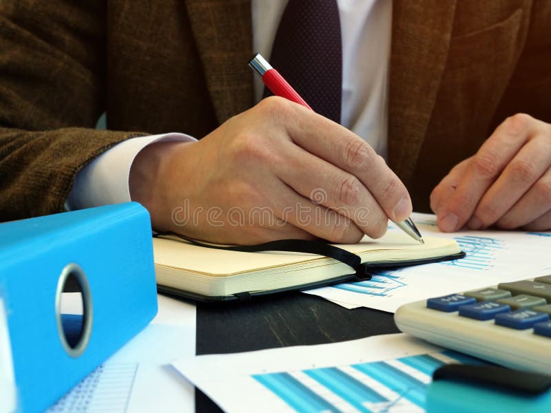 Businessman Makes Notes in the Notepad. Man is Writing in the Office ...