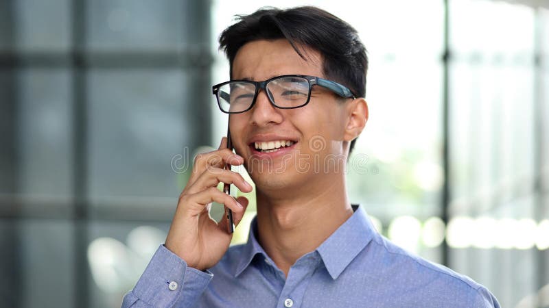 Businessman Making a Phone Call while Standing in the Lobby of a Modern ...