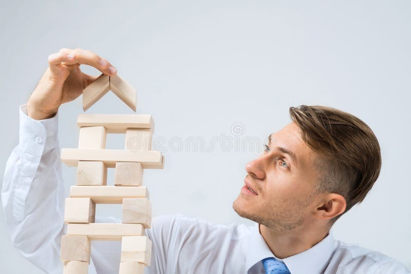 Businessman making tower stock photo. Image of concept - 77010794