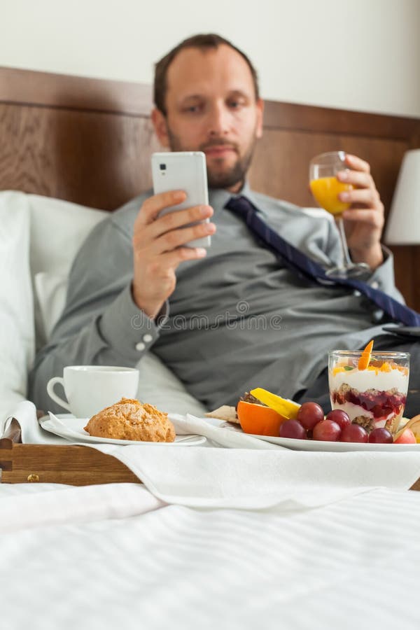 Businessman with Mobile Phone during Breakfast. he is Lying on B Stock ...