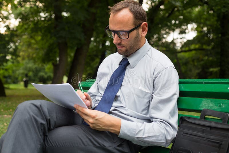 Businessman with Notes and Pen Sitting on a Bench in Park. Stock Photo ...