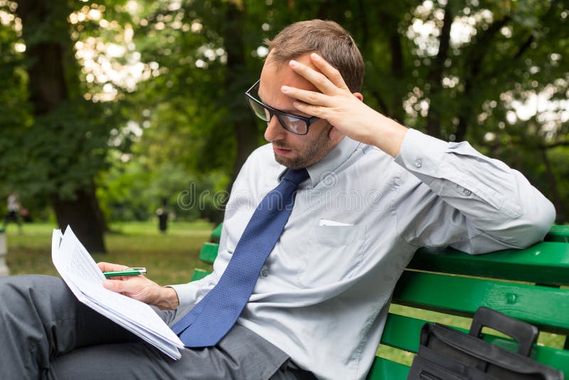 Businessman with Notes and Pen Sitting on a Bench in Park. Stock Image ...