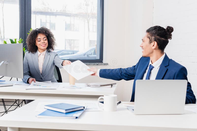 Businessman Passing Documents To His Female Colleague Stock Photo ...