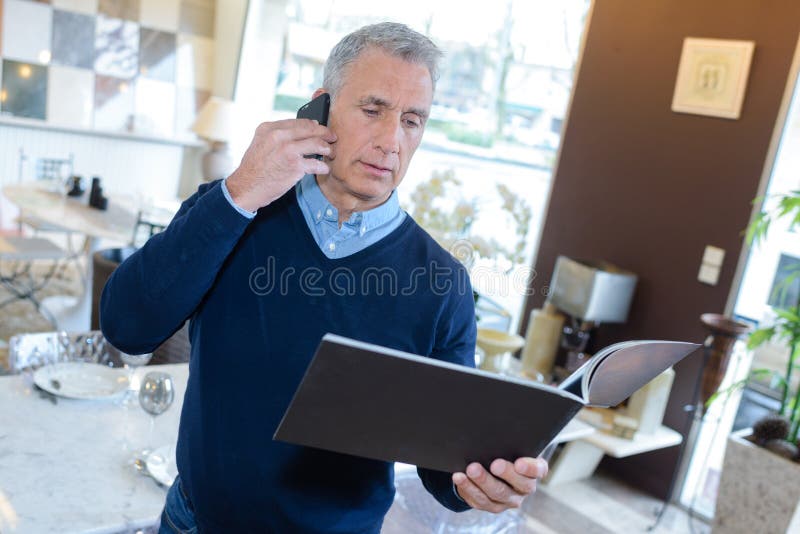 Businessman on Phone Looking Up Information in File Stock Photo - Image ...