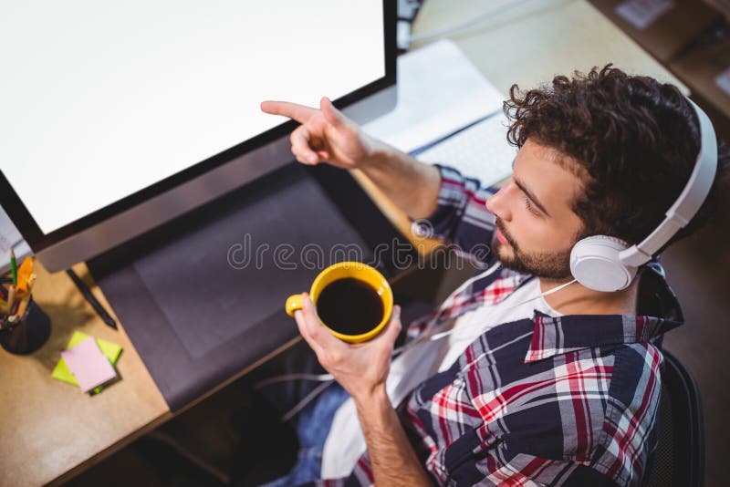 Businessman Pointing at Computer Monitor while Drinking Coffee Stock ...
