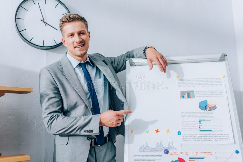 Businessman Pointing at Papers with Graphs Stock Photo - Image of ...