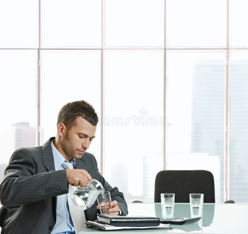 Businessman pouring water stock image. Image of indoor - 18040107