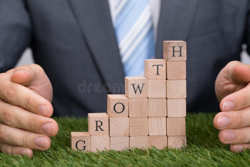 Businessman Protecting Growth Blocks on Grass Stock Image - Image of ...