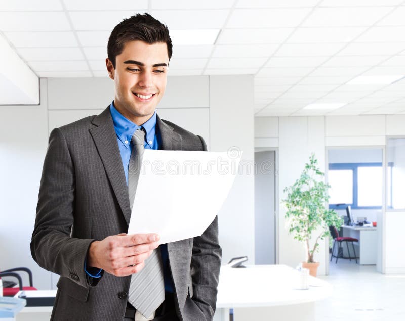 Businessman Reading a Document Stock Image - Image of smile, looking ...