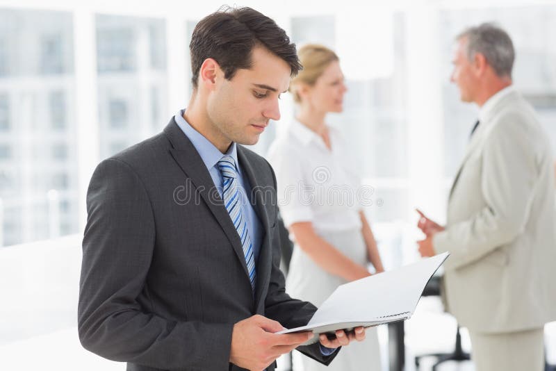 Businessman Reading Over a Document Stock Image - Image of male, woman ...