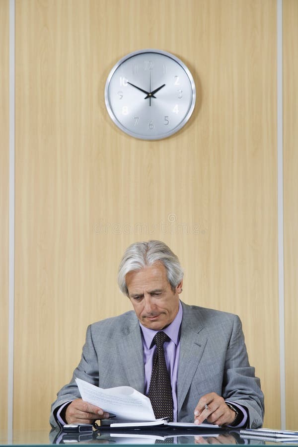 Businessman Reading Papers in Office Stock Image - Image of businessman ...