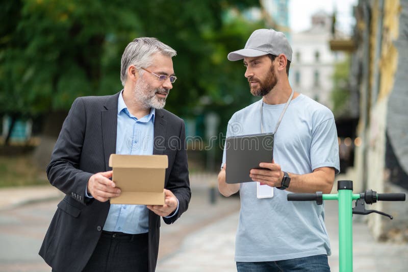 Businessman Receiving a Delivery Box from the Courrier on a Scooter ...