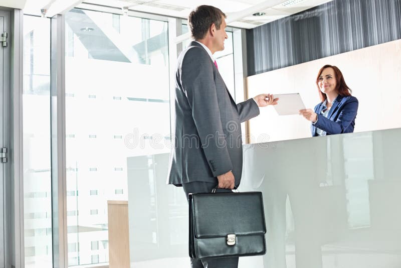 Businessman Receiving Document from Receptionist in Office Stock Photo ...