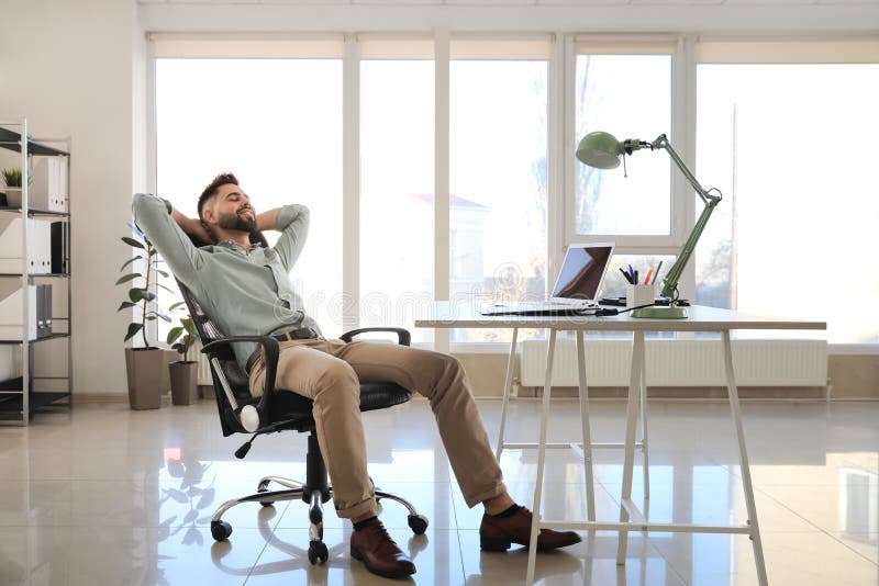 Businessman Relaxing in Office Chair at Workplace Stock Photo - Image ...
