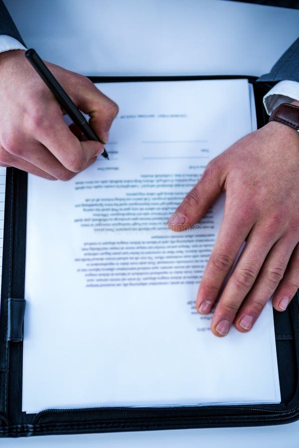 Businessman Signing Contract While His Partner Is Looking At Him Stock ...