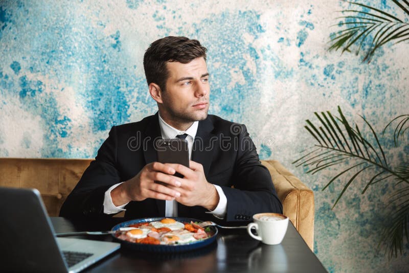 Businessman Sitting in Cafe Using Laptop Computer Have a Breakfast or ...