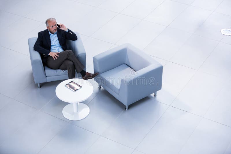 Businessman Sitting on a Chair and Talking on Mobile Phone Stock Photo ...