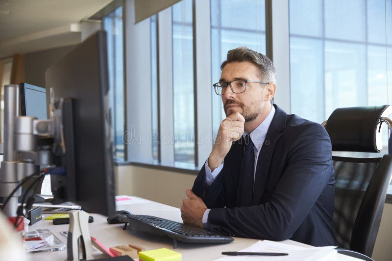 Businessman Sitting at Desk in Office Using Computer Stock Image ...