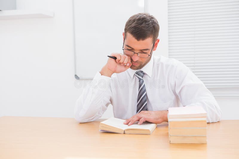 Businessman Sitting at Desk Reading Books Stock Image - Image of ...