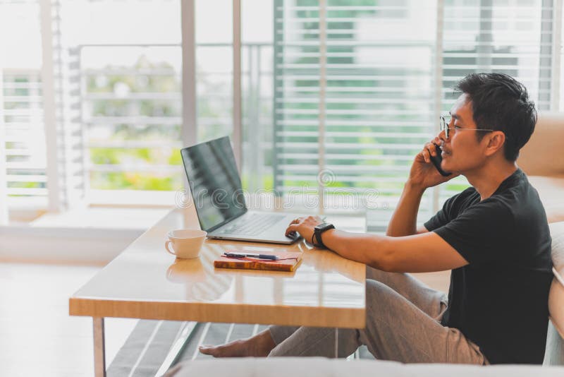 Businessman Sitting on Floor at Home Having a Call while Working on ...