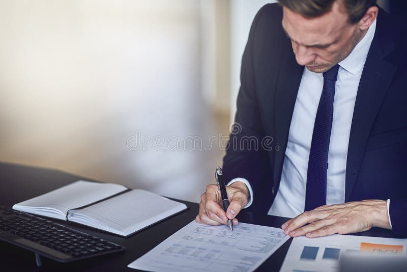 Businessman Sitting at His Office Desk Looking Over Documents Stock ...