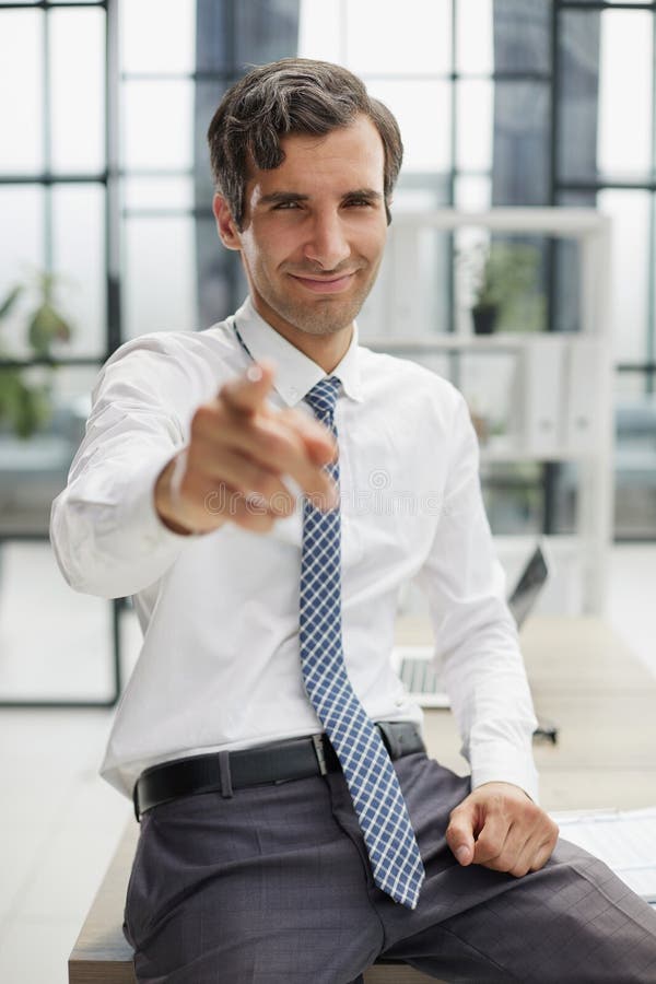 Businessman Sitting on the Table and Pointing at You Stock Photo ...