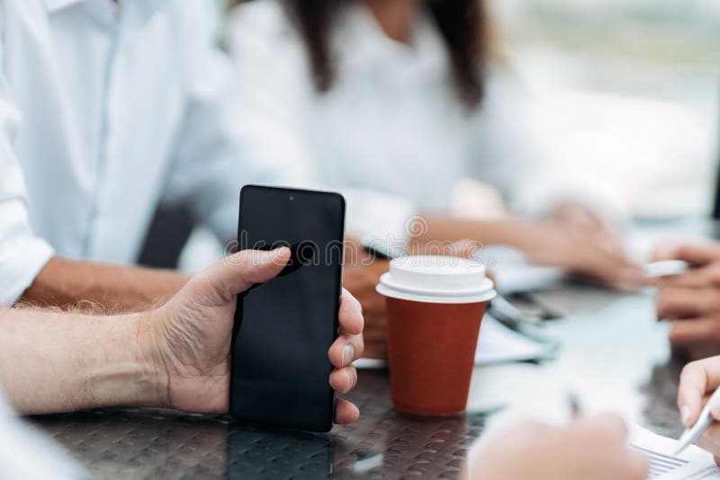 Businessman with a Smartphone Sitting at a Discussion Table. Stock ...