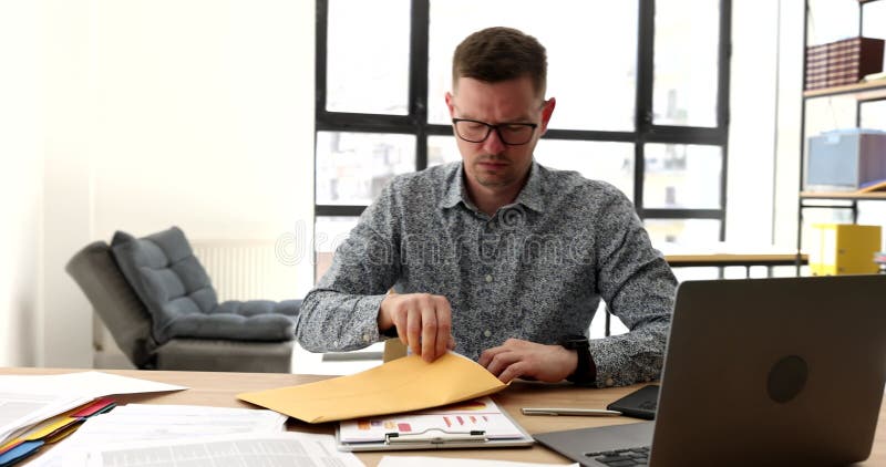 Businessman Sorting Mail at Table and Opening Yellow Envelope in Office ...