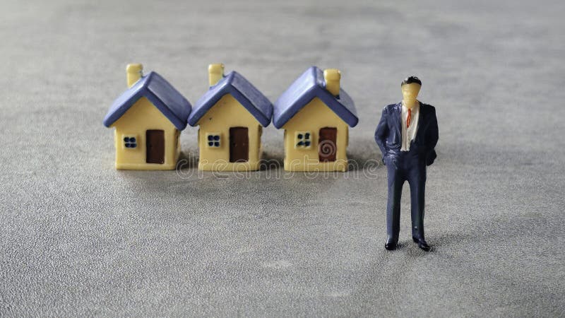 A Businessman Standing in Front of a Row of Miniature House Stock Photo ...