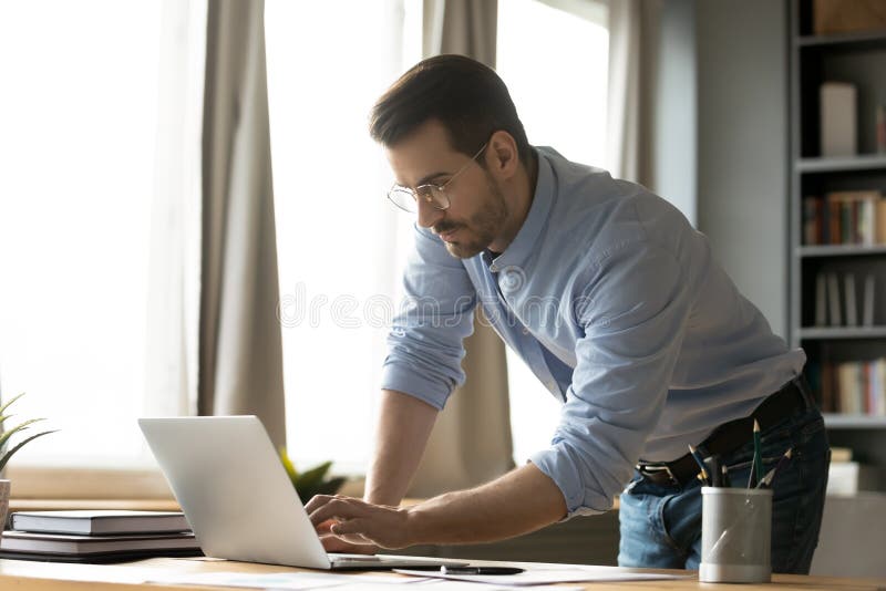 Businessman Standing Lean Over Workplace Desk Working on Wireless ...