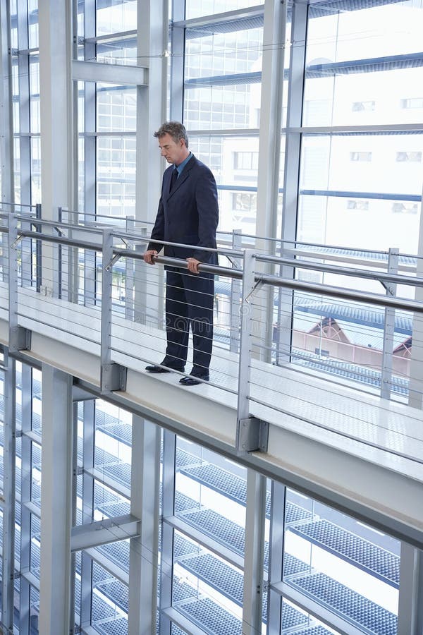 Businessman Walking By Railing In Modern Office Stock Photo - Image of ...