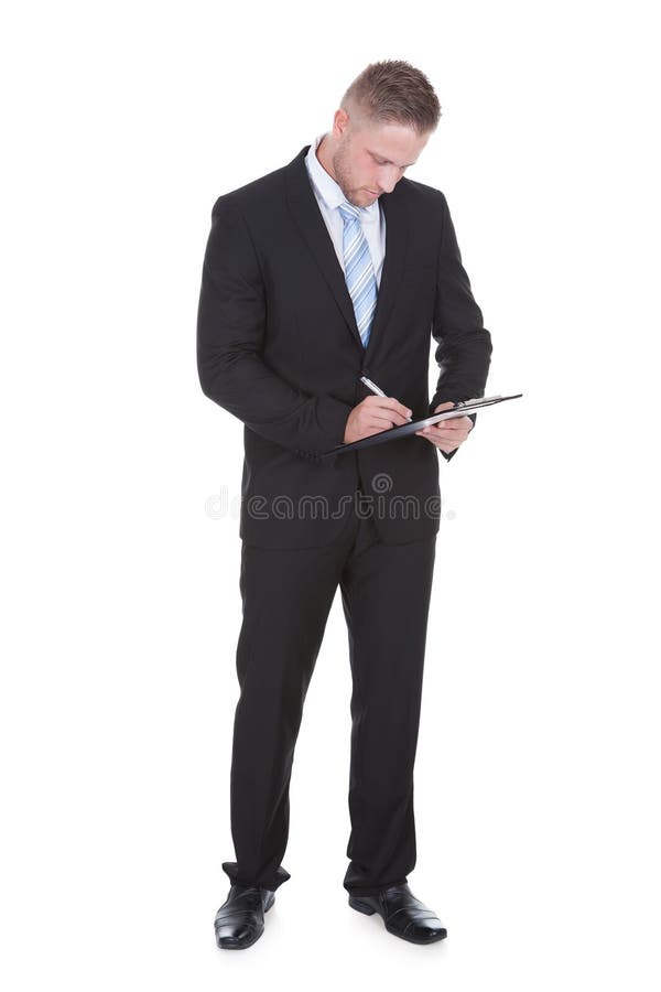 Businessman Standing Writing on a Handheld Clipboard Stock Image ...