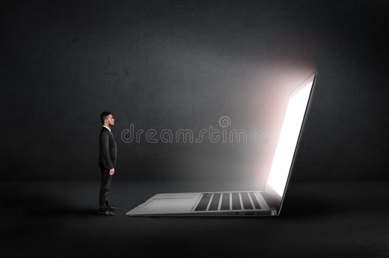 Businessman Stands Front of an Open Glowing Huge Laptop in the Darkness ...