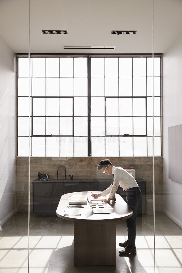Businessman Stands Working Alone in an Office, Vertical Stock Image ...