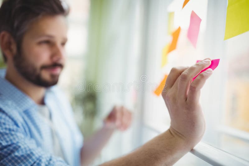 Businessman Sticking Adhesive Notes on Glass Window at Creative Office ...