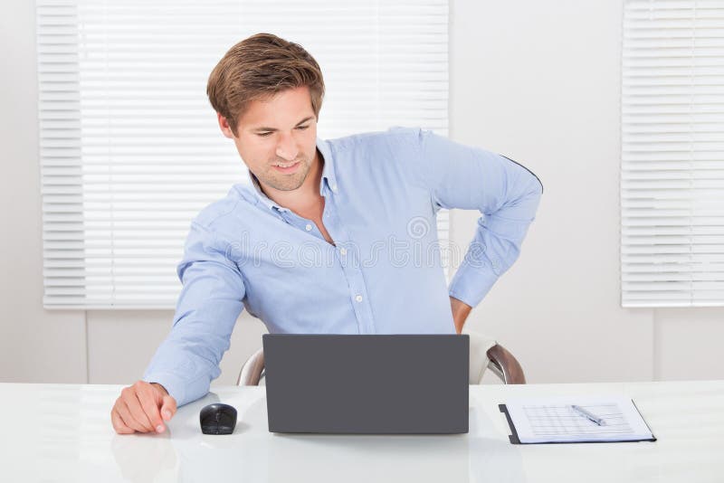 Businessman Suffering from Backache while Working on Laptop Stock Photo ...