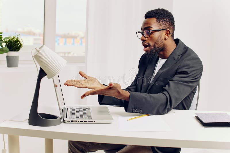 Businessman in a Suit Presenting Ideas at a Desk with an Open Laptop ...