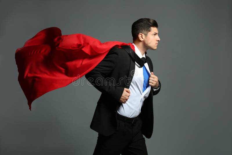 Businessman in Superhero Cape Taking Suit Off on Grey Stock Photo ...