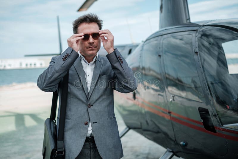 Businessman Talking on Cellphone Near Private Helicopter Stock Image ...