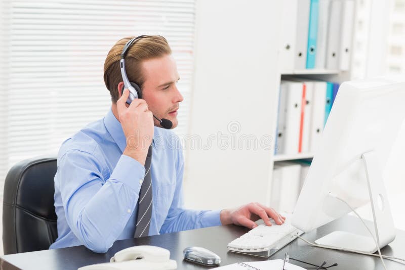 Businessman Typing at Computer while Speaking with Headset Stock Image ...