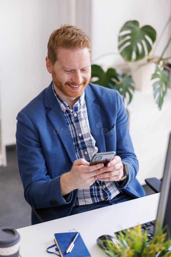 Businessman Typing Text Message Using Smart Phone while Working in an ...