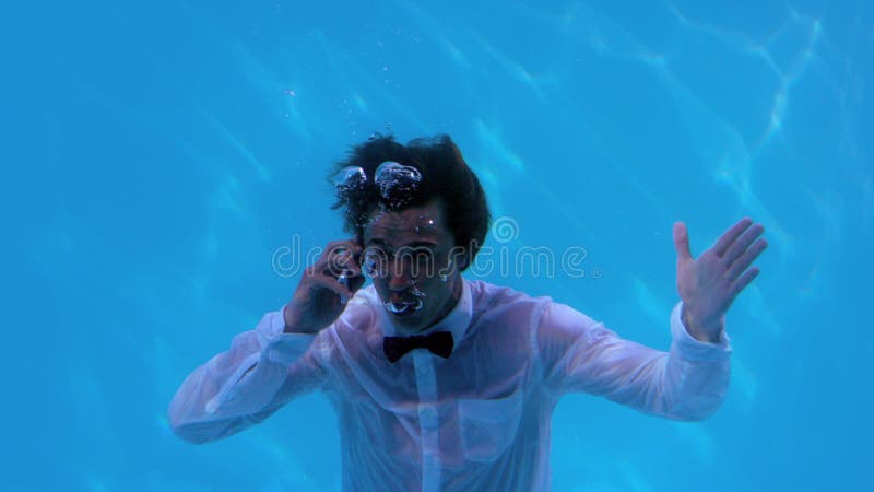 Businessman Underwater in Swimming Pool Talking on Smartphone Stock ...