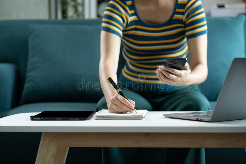 Businessman Use a Smartphone and Take Notes in the Notebook at the ...