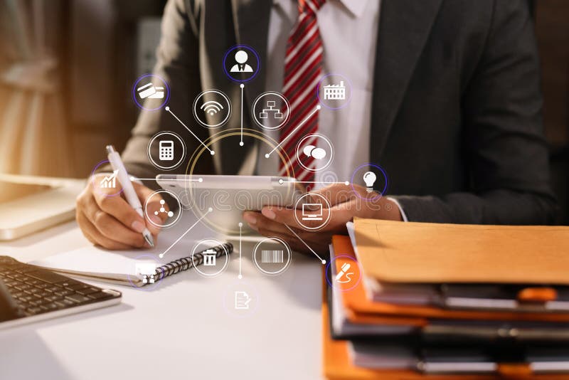 Businessman Use a Tablet Computer and Take Notes in the Notebook at the ...