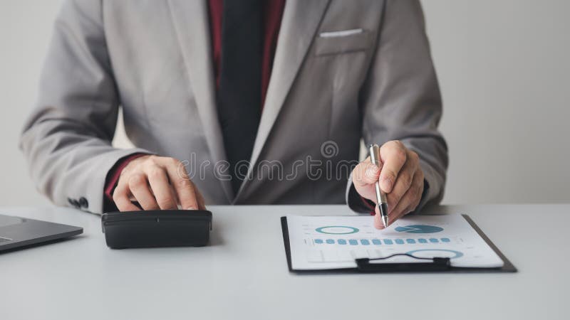 Businessman Using a Calculator To Calculate Numbers on a Company S ...