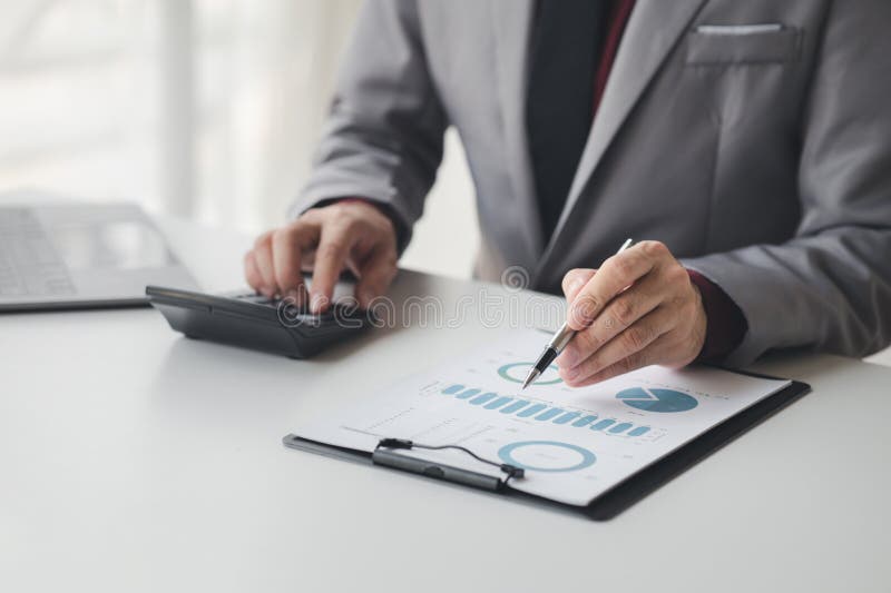 Businessman Using a Calculator To Calculate Numbers on a Company S ...