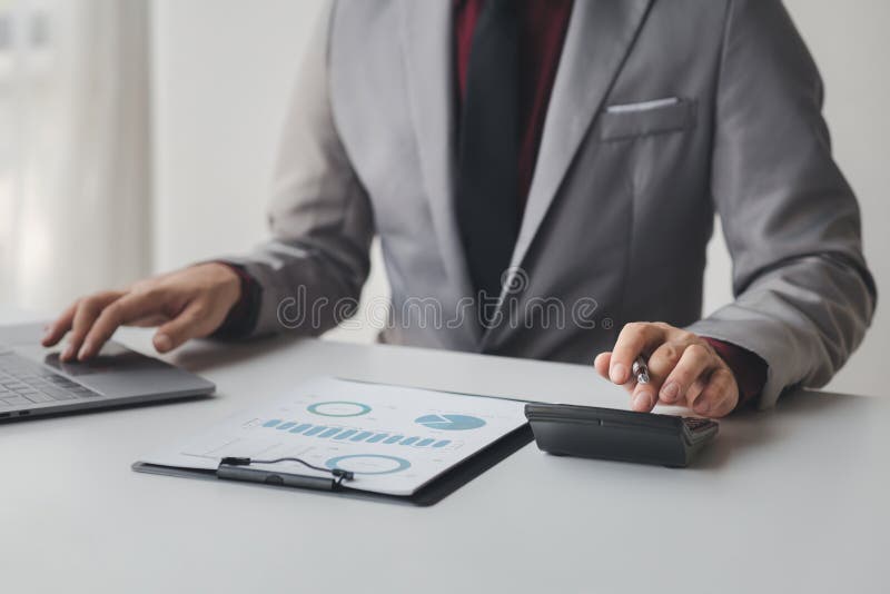 Businessman Using a Calculator To Calculate Numbers on a Company S ...