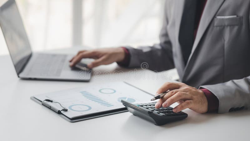 Businessman Using a Calculator To Calculate Numbers on a Company S ...